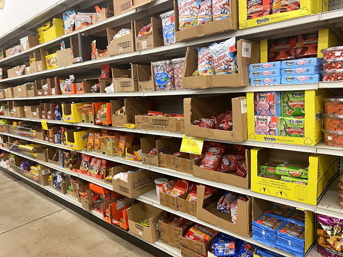 Snack aisle or treasure hunt? Name-brand treats line these shelves like refugees from expensive grocery stores, waiting for adoption.