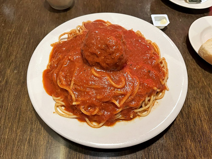 This isn't just spaghetti and meatballs; it's a gravity-defying monument to the art of sauce-making, with meatballs the size of bocce balls.