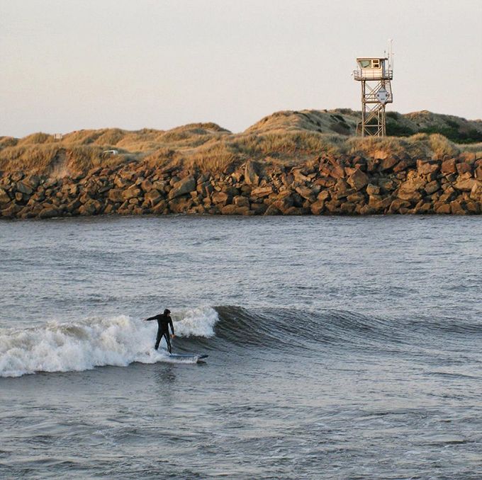 Surf's up at South Jetty! While some come for tranquil hikes, others chase that perfect wave alongside the rocky jetty. 