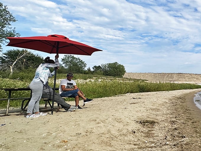 Beachside relaxation, Kansas-style. The red umbrella isn't just practical&mdash;it's the exclamation point on a perfect lakeside afternoon.
