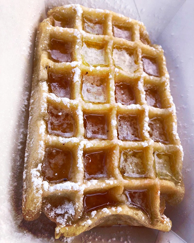 Golden, crispy squares holding pools of maple syrup&mdash;this isn't just a waffle, it's edible architecture designed for maximum happiness delivery.