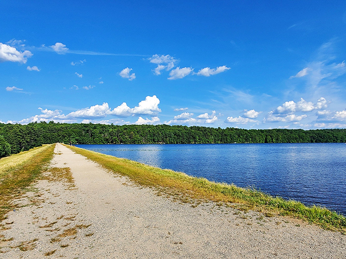 Ashland's reservoir path stretches into the distance, promising solitude between blue waters and lush forest on both sides.