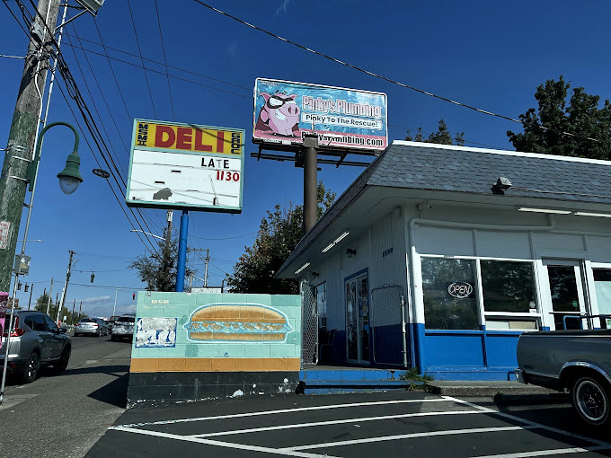 MSM Deli's blue and white building stands like a sandwich lighthouse, guiding hungry Tacoma residents to flavor salvation.