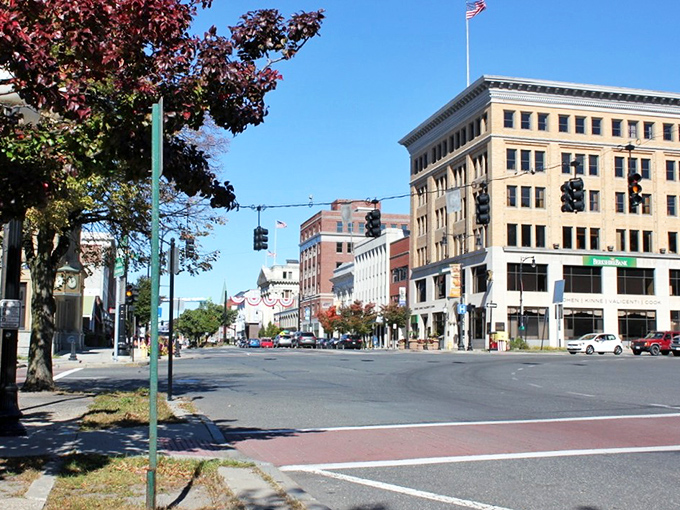 Explore the bustling heart of Pittsfield as you discover charming shops and grand architecture lining this vibrant, sunlit downtown street.