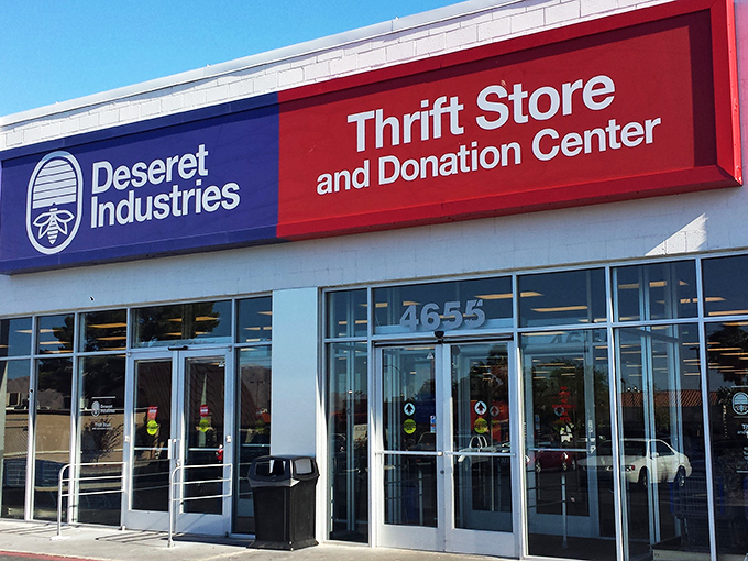 The blue and red signage of Deseret Industries stands like a beacon of bargain hope in the desert retail landscape.