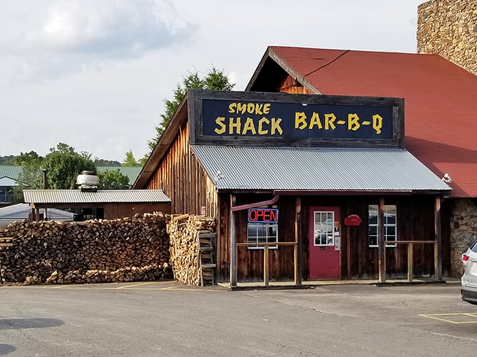 That bright red door is your portal to flavor town. The woodpile outside hints at the smoky goodness waiting inside.