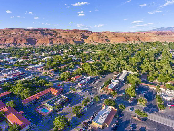 The desert oasis revealed from above—a patchwork of green against red, where streets form a grid and adventure forms the lifestyle.