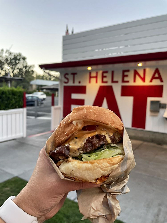 The perfect burger portrait&mdash;juicy patty, melted cheese, and fresh lettuce framed by the "EAT" sign, like the Mona Lisa of fast food.