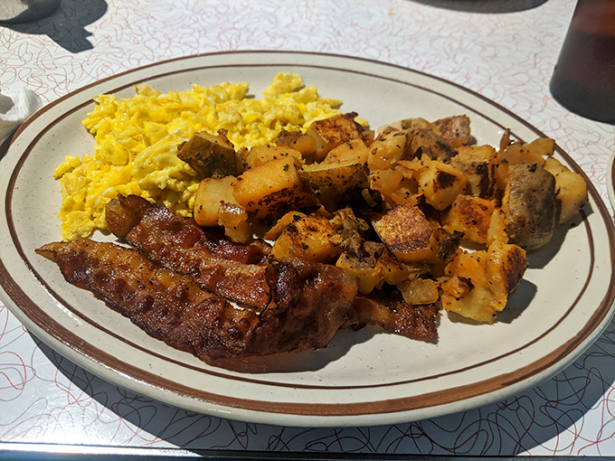 The holy trinity of breakfast perfection: crispy bacon with just the right chew, golden eggs, and home fries that actually taste like they've met a potato.