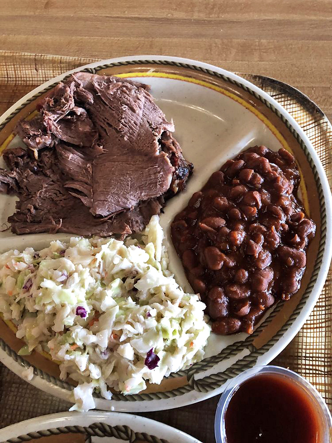 A holy trinity of barbecue perfection: tender beef, creamy coleslaw, and beans that have clearly been simmering since breakfast. This plate doesn't need Instagram filters.