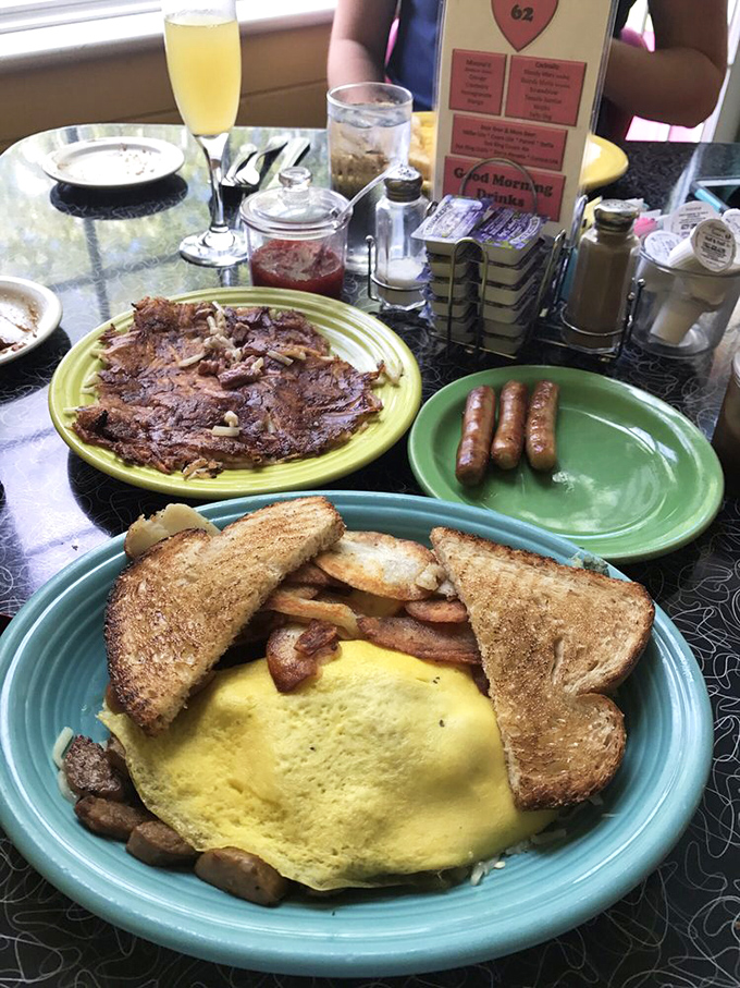 The breakfast trinity: golden omelet, perfectly toasted bread, and the legendary corned beef hash. Add mimosas and you've achieved morning nirvana.