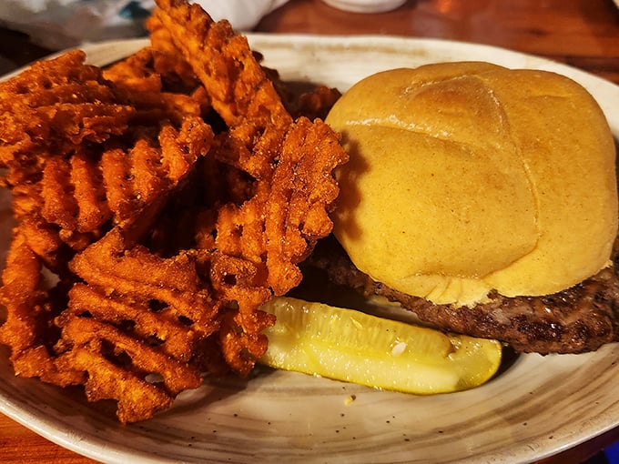 A burger that requires strategic planning&mdash;note the waffle fries standing at attention like delicious golden soldiers ready for duty.
