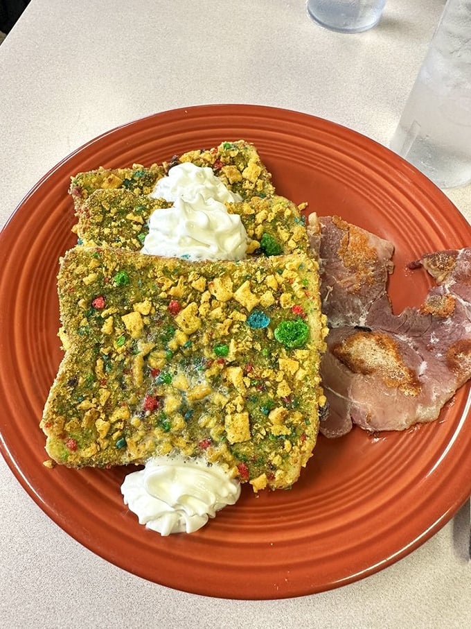 Not your average French toast! Crushed Captain Crunch creates a technicolor crust that transforms ordinary bread into a carnival of sweetness with whipped cream islands.