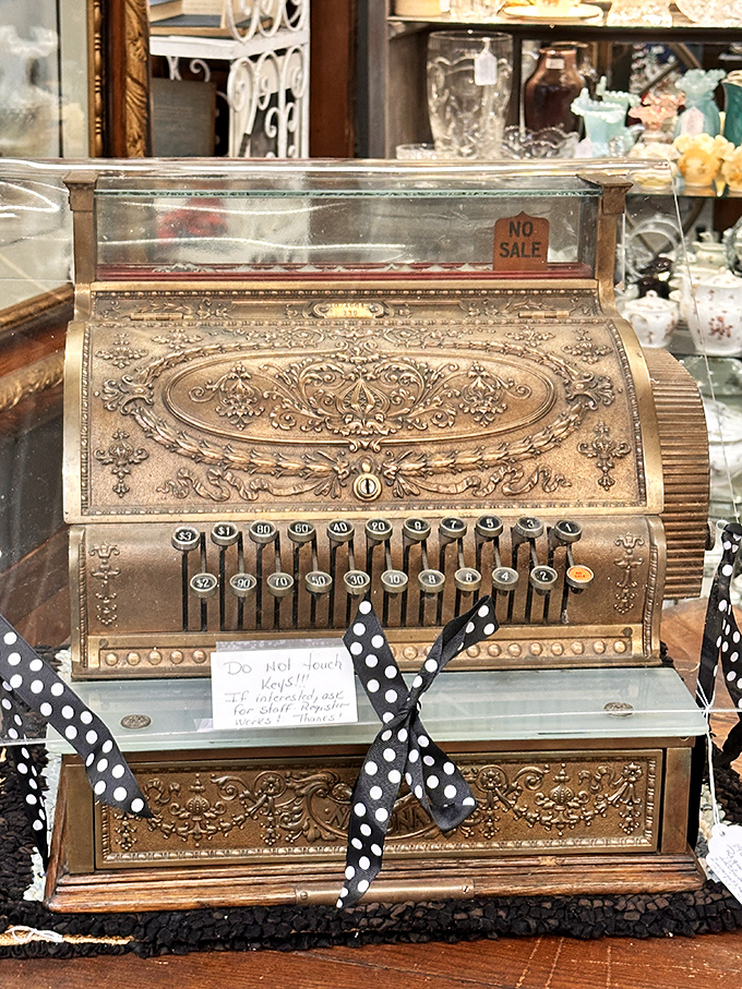 This ornate antique cash register wasn't just functional&mdash;it was theater. The "Do Not Touch Keys" sign is the modern equivalent of "look with your eyes, not with your hands."