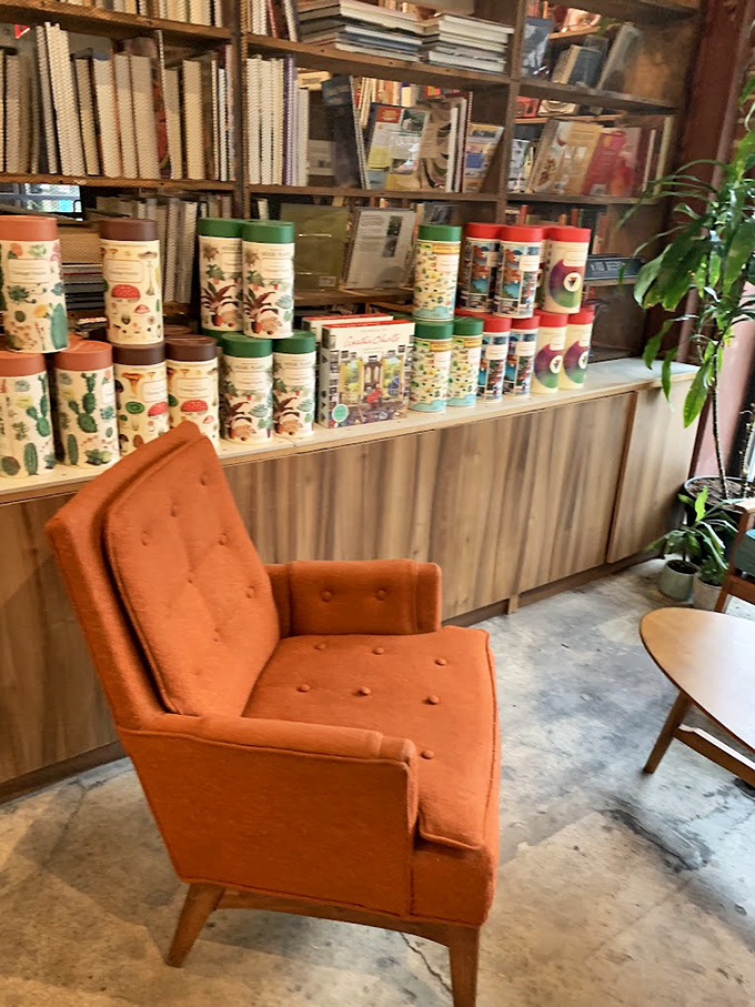 That burnt-orange mid-century chair isn't just seating; it's a literary throne waiting for you to claim it and disappear into another world for hours.