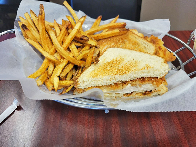 Golden-crisp grilled cheese perfection with hand-cut fries that could make a French chef weep. Comfort food poetry on a metal basket.