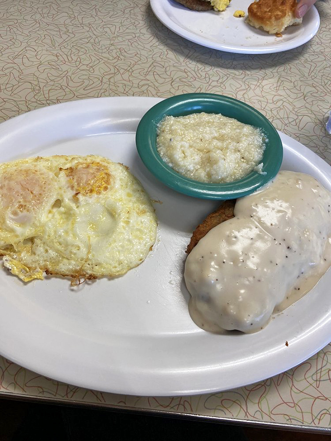 Behold! The elusive perfectly-fried country steak, its golden crust barely visible beneath a lava flow of pepper-speckled gravy, paired with sunny-side-up eggs.