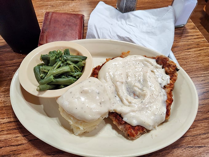 The holy trinity of comfort food: perfectly breaded chicken fried steak, creamy mashed potatoes, and green beans that actually taste like vegetables.