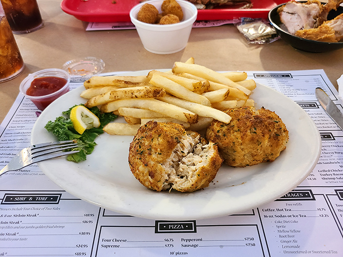 The classic combo: crab cakes with fries. One bite reveals the delicate balance between crispy exterior and sweet, lump crabmeat within.