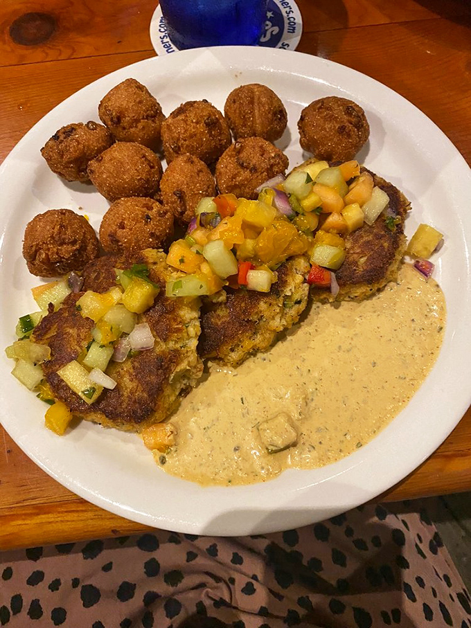 The ultimate seafood power couple: crab cakes with their crispy sidekicks, hush puppies. Like Batman and Robin, if they were delicious and dipped in remoulade.