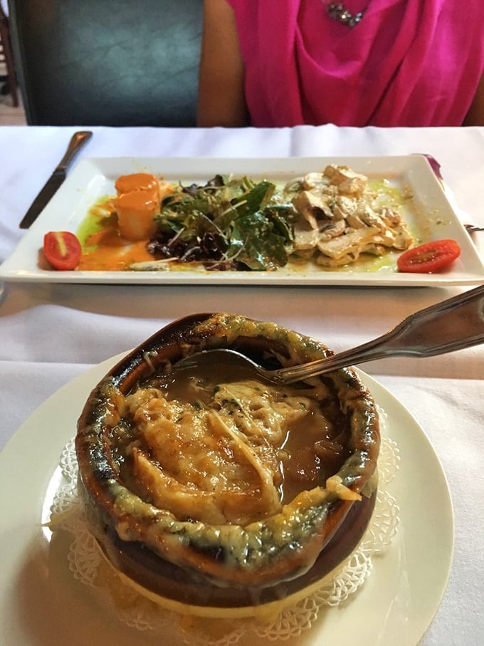 When the French onion soup arrives, all conversation stops. That moment when the spoon breaks through the cheese crust is pure culinary theater.
