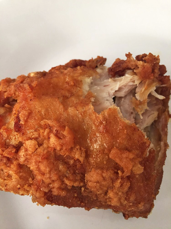 The cross-section reveals the holy grail of fried chicken: shatteringly crisp exterior giving way to juicy, tender meat. Poetry in poultry form.
