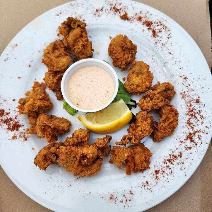Golden-fried oysters arranged in a perfect circle, like a crispy crown for seafood royalty. The dipping sauce is just showing off.