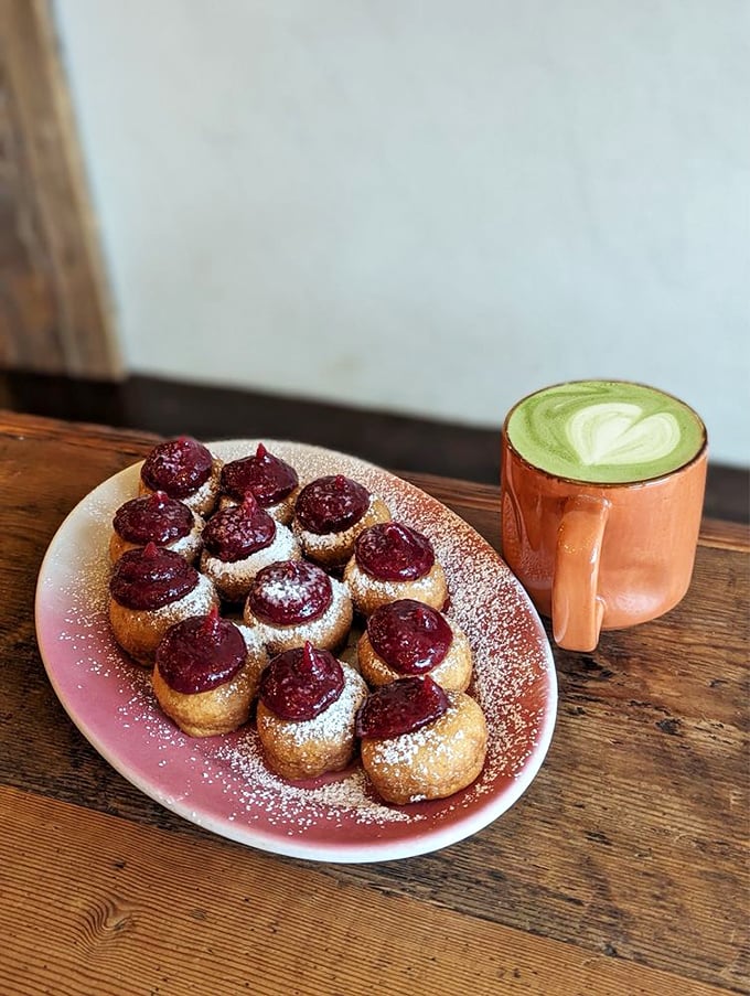 Green tea matcha latte artfully paired with ruby-red berry-topped donuts creates the kind of breakfast experience that turns first-timers into regulars.