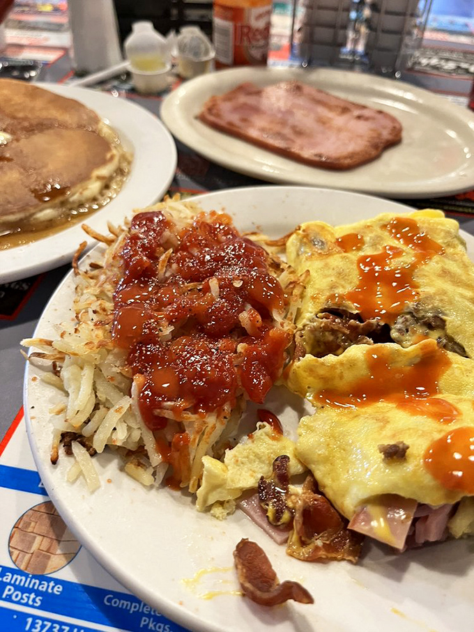 Breakfast alchemy at its finest—hash browns with the perfect crisp-to-tender ratio and an omelet stuffed with morning dreams.