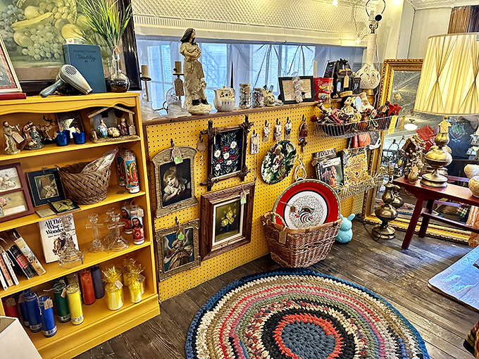 A colorful braided rug anchors this cozy vignette where religious figurines, vintage glassware, and framed artwork create a nostalgic snapshot of Americana.