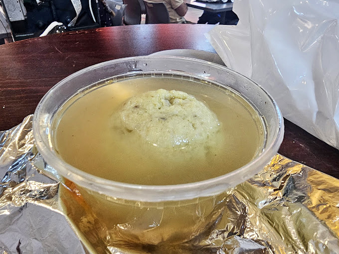 The matzo ball floats majestically in clear broth like the moon reflecting on a perfect lake. One spoonful and you'll understand why people line up.