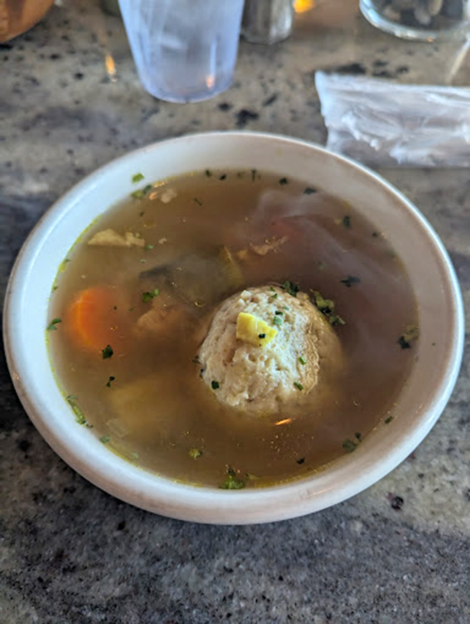 One perfect matzo ball floating like the moon in a constellation of herbs and vegetables. This is the dumpling that dreams are made of.