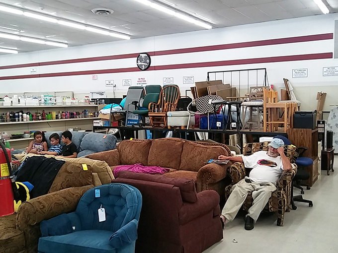The furniture testing zone, where one man's impromptu nap is another's quality control. That brown sofa has stories to tell.