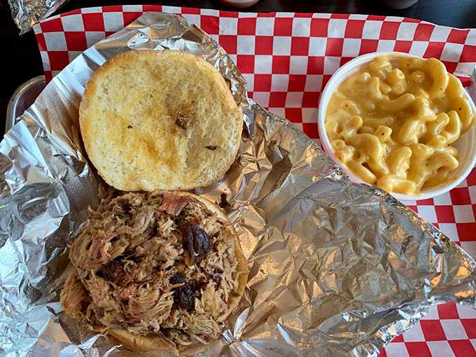 Barbecue architecture at its finest&mdash;pulled pork nestled on foil, ready for its bun, with mac and cheese standing by for moral support.
