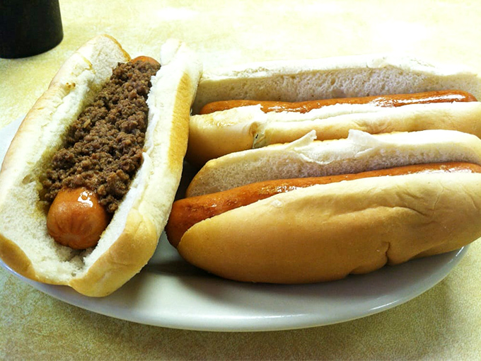 The holy trinity of hot dog heaven: chili, mustard, and onions. Three simple ingredients that create a symphony in a bun.