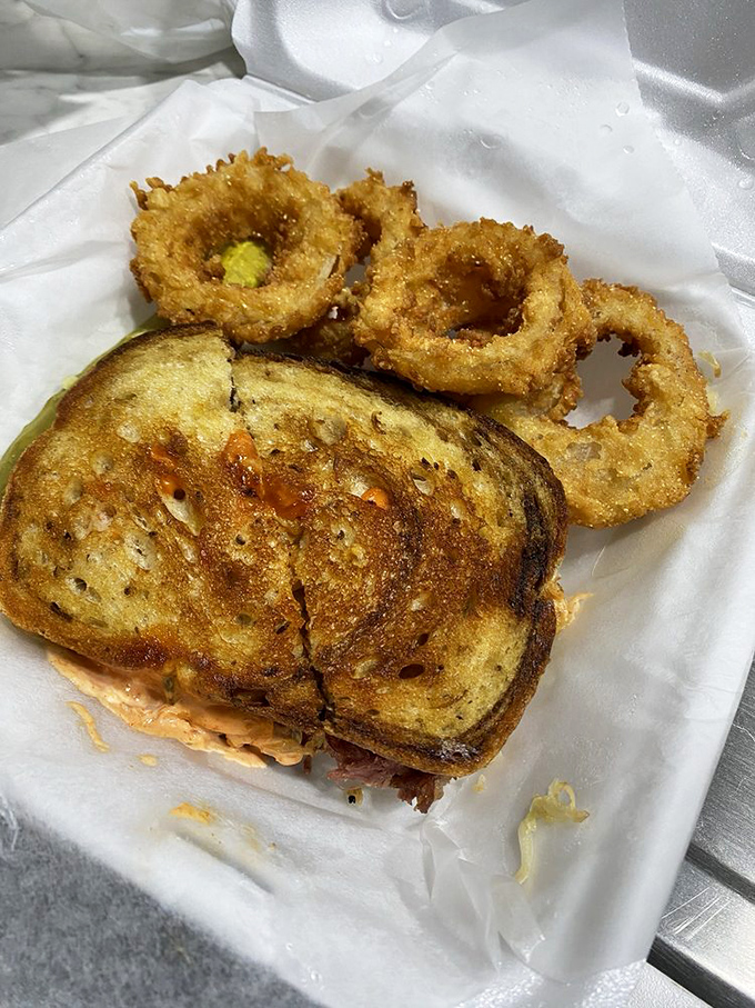 The Reuben's perfect sidekick? Golden, crispy onion rings that shatter with each bite. This is what happiness looks like on a plate.