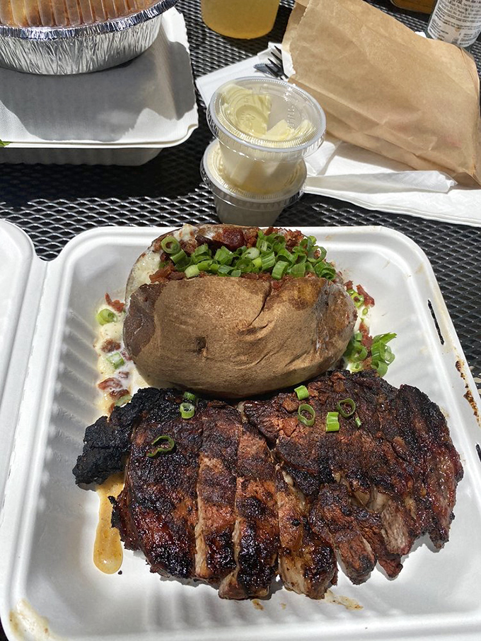 A study in contrasts: blackened exterior giving way to pink perfection, alongside a baked potato that's practically begging for its close-up.