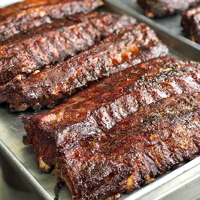 These ribs aren't just cooked&mdash;they're carefully coaxed into greatness over 14 hours, resulting in that perfect pink smoke ring barbecue aficionados dream about.