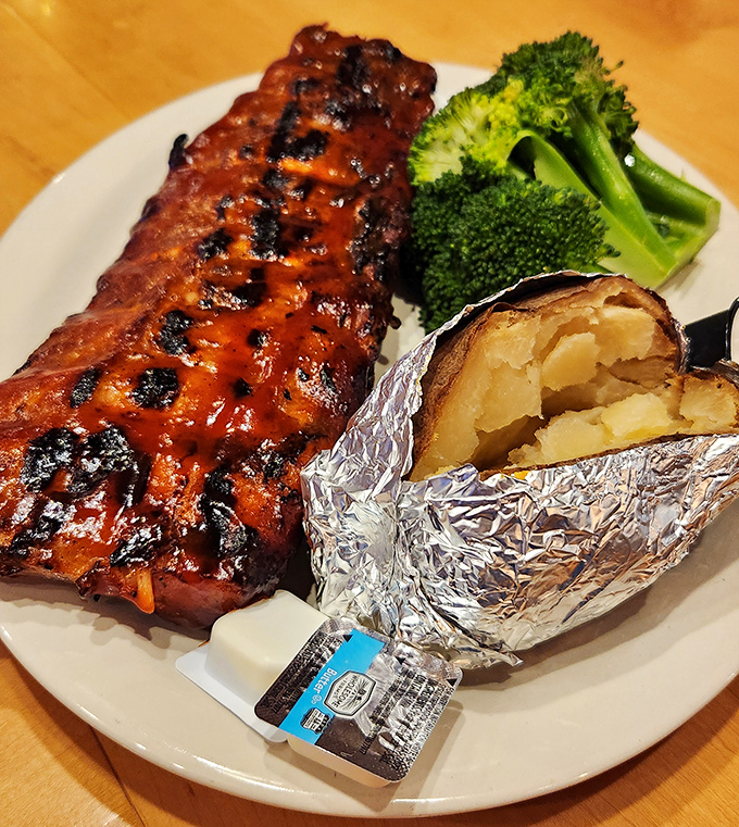 This rack of ribs has that glistening, lacquered finish that belongs in a barbecue museum, with a foil-wrapped potato playing worthy sidekick.