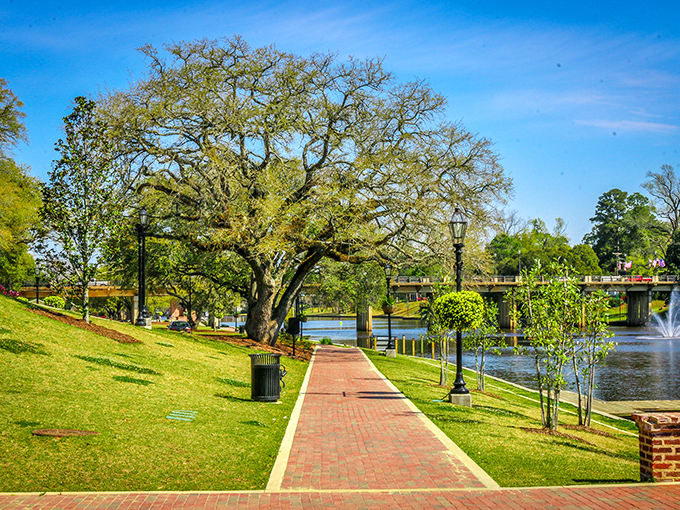 A brick pathway hugs the riverbank beneath ancient oaks, offering the kind of stroll that makes you wonder why you ever rush anywhere.