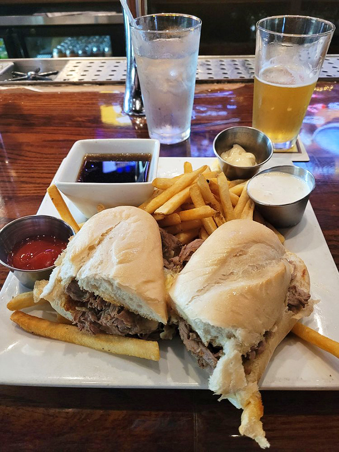 The French Dip in its natural habitat: flanked by golden fries, accompanied by dipping sauces, and just begging to be introduced to your taste buds.