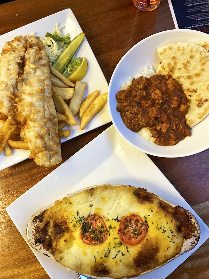 The holy trinity of British comfort food—golden fish and chips, hearty Shepherd's Pie, and what appears to be a proper curry with naan.