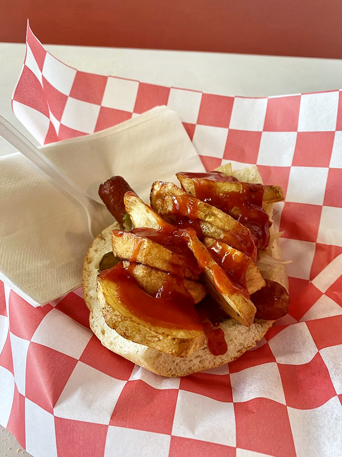 The single Italian hot dog on its red-checkered throne&mdash;more potatoes than should legally fit in one sandwich, yet somehow, gloriously right.