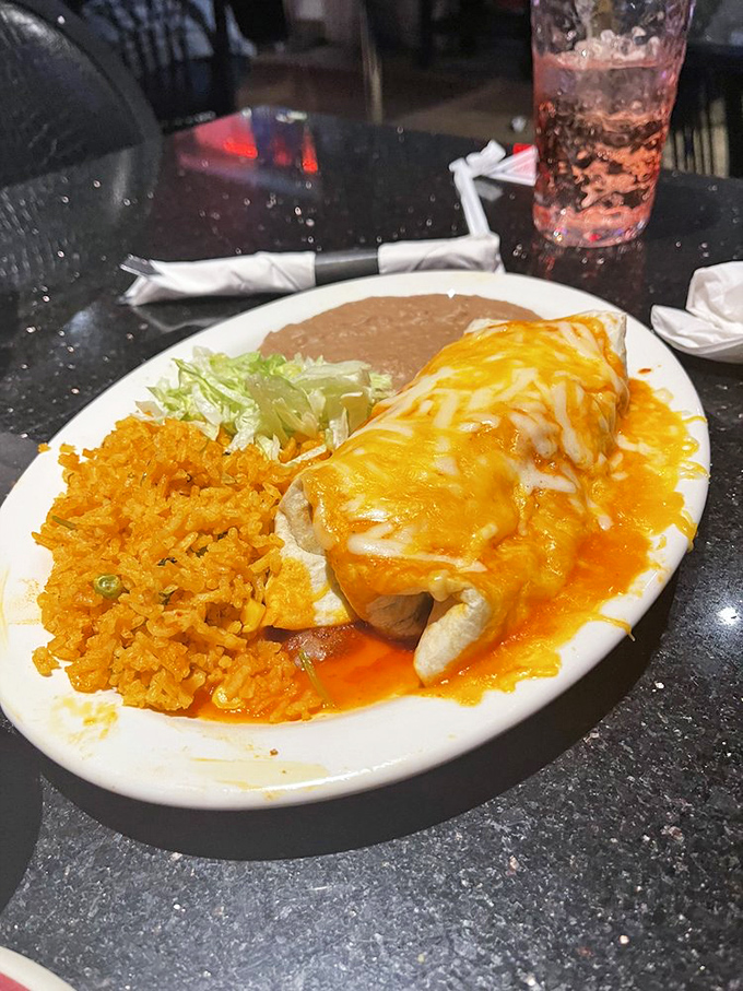 This cheese-blanketed burrito isn't just smothered&mdash;it's embraced, comforted, and told everything's going to be alright. The orange sauce practically glows with promise.
