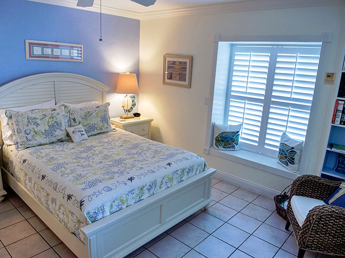Coastal elegance meets timeless comfort in this serene bedroom, where soft blue walls echo the nearby Atlantic and white shutters filter Florida's famous sunshine.
