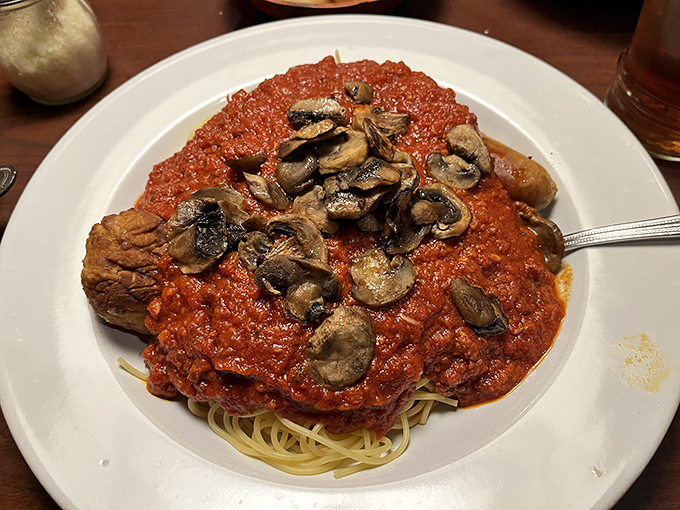 A mountain of meat sauce with mushrooms stands proudly atop pasta, like Vesuvius if it erupted with deliciousness instead of lava.