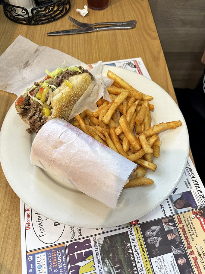 This steak sandwich isn't just lunch&mdash;it's edible therapy wrapped in paper, with a side of golden fries that crackle with each bite.
