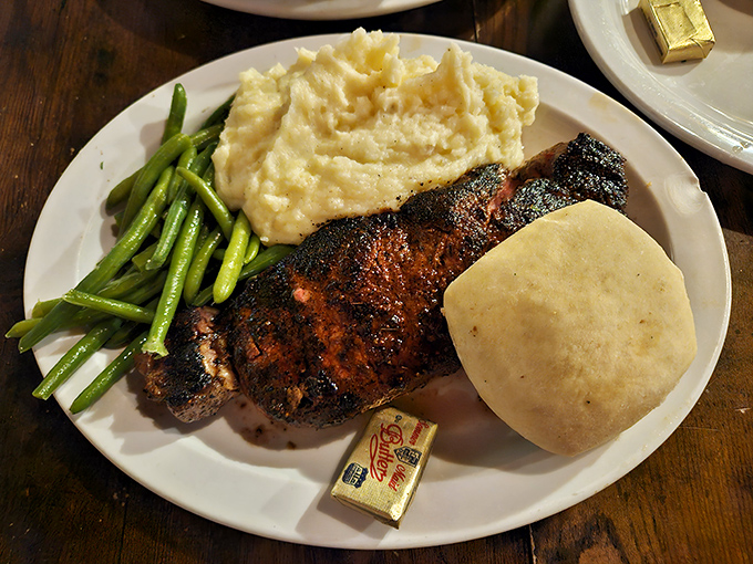Green beans, mashed potatoes, and a steak with the perfect char. Southern comfort arranged on a white plate, with butter standing by for backup.