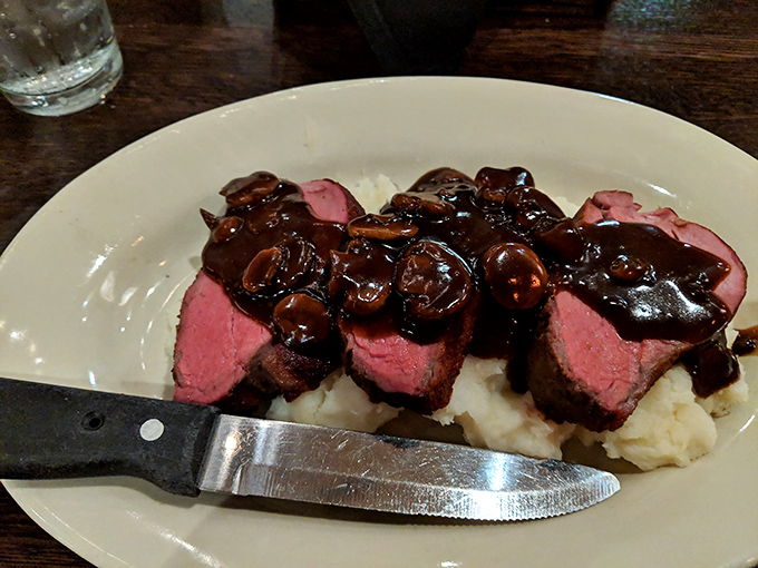 Steak and mushroom sauce over mashed potatoes—comfort food elevated to an art form that would make your grandmother both proud and jealous.