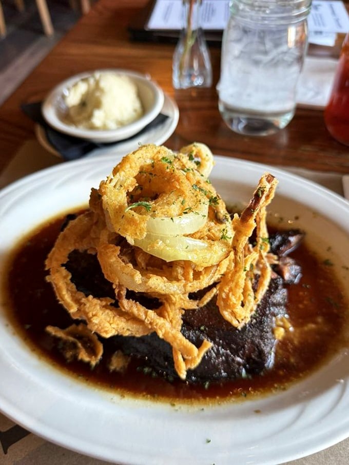 When a perfectly seared steak meets a crown of crispy onion rings, it creates the kind of dish that inspires poetry &ndash; or at least very enthusiastic mumbling.